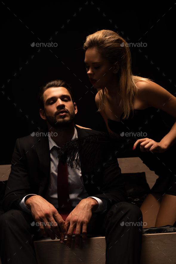 beautiful passionate couple of lovers playing with feather on bed in ...