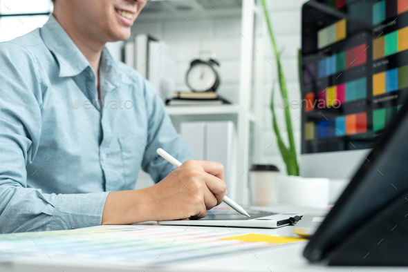 Male graphic designer is choosing color swatch samples on multiple ...