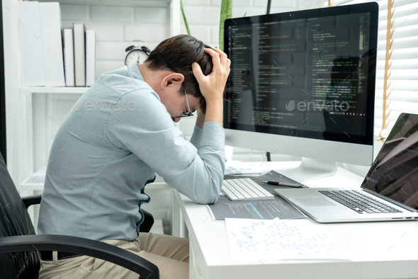 Male programmer feeling headache and stress during checking program ...
