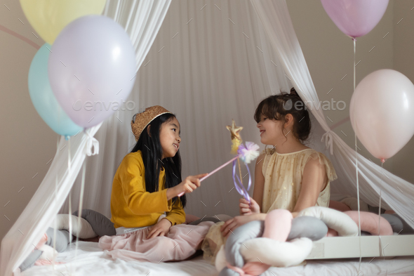 Happy girls playing princess with princess wands in a play tent. Stock ...
