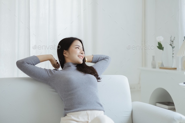 woman stretching relax. She is relaxing on the sofa in the living room ...