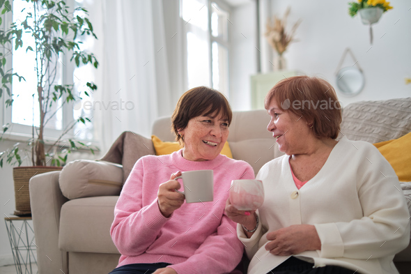 Embracing the golden days: Two delightful senior women relishing a hot ...