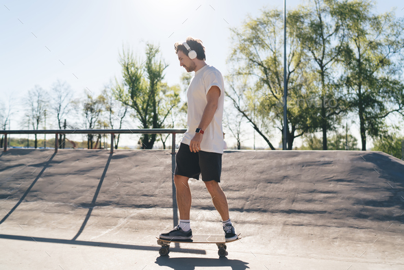 Young man riding skateboard on skate park Stock Photo by GaudiLab ...