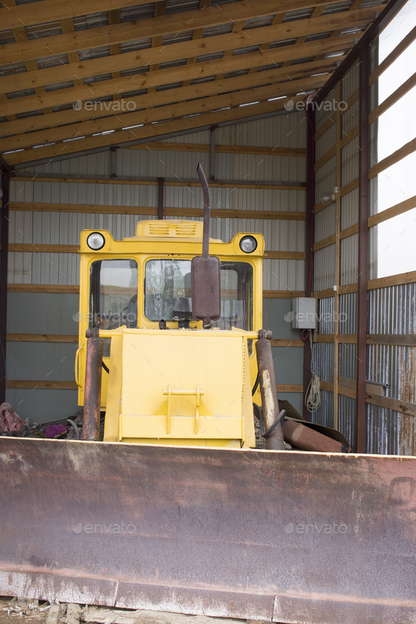 Large wheeled tractor with a dozer blade for clearing roads from snow ...