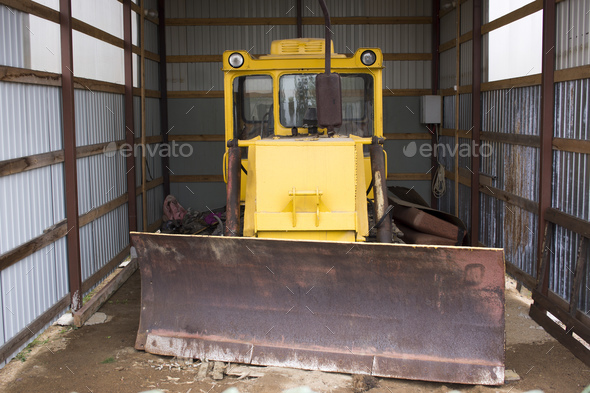Large wheeled tractor with a dozer blade for clearing roads from snow ...