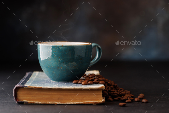 Rich coffee in a cup with aromatic roasted beans Stock Photo by karandaev
