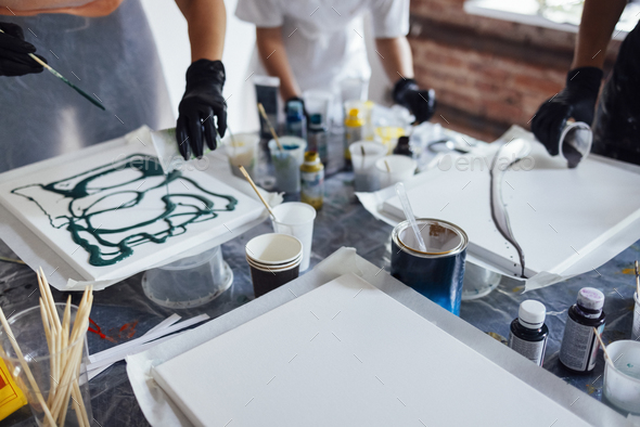 Master class on an Acrylic Fluid Pouring. Young women paint with liquid ...