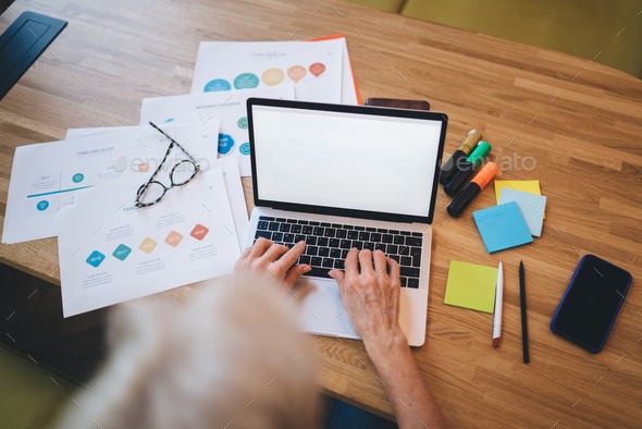 Documents near glass wall while working on project in modern workspace ...