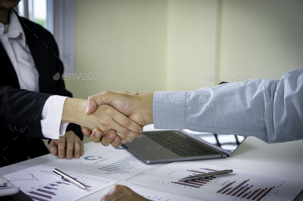 female finance staff is shakeing hands to congratulate With her ...