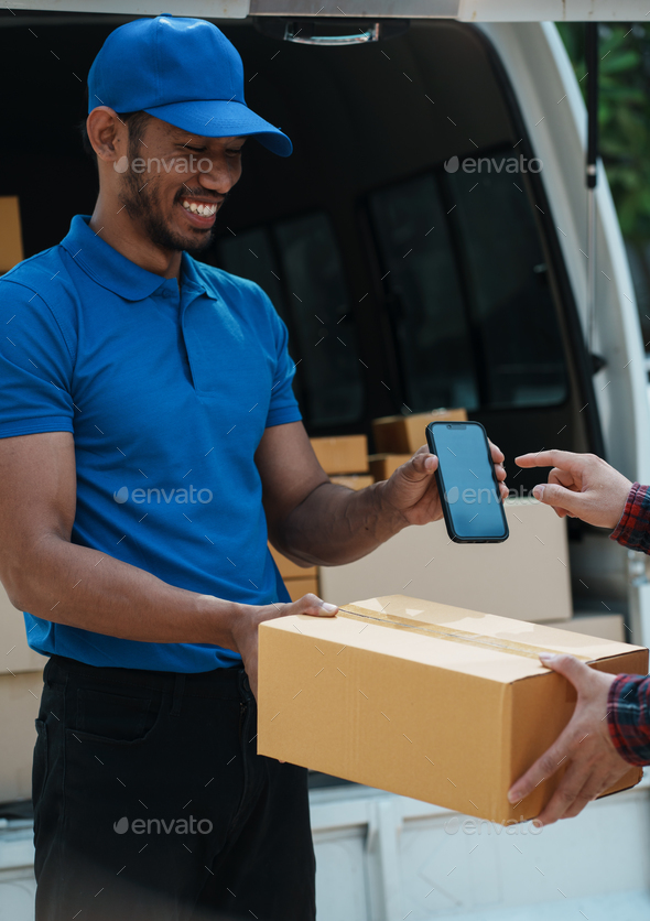 Delivery man handing parcel box to customer, percel box being paid with ...