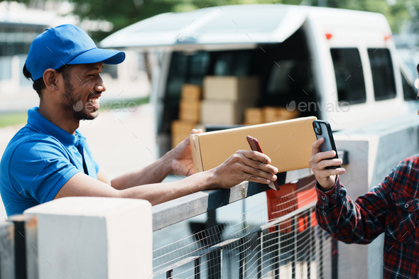Delivery man handing parcel box to customer, percel box being paid with ...