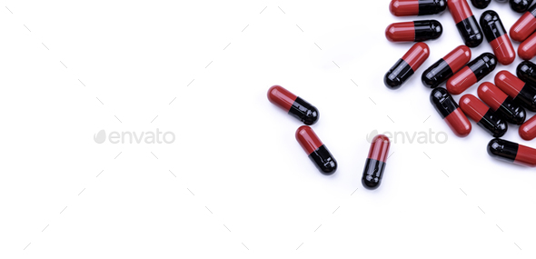 Top view red-black antibiotic capsule pills on white background ...