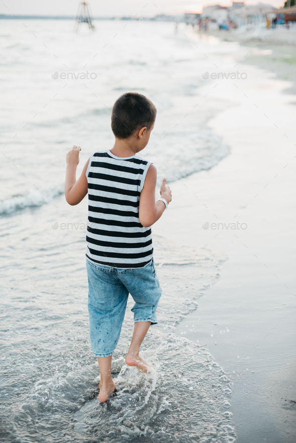 Child running on the beach. Summer vacation. happy kid playing on beach ...