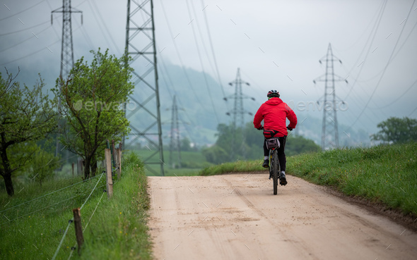 Older man cycling through the countryside Stock Photo by dreamypixel