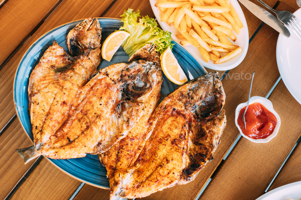 Dish with Gilt-head bream Fish With orange and french fries. Dorada ...