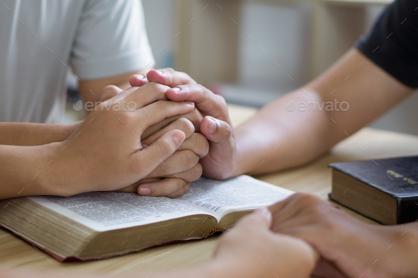 Prayer meeting concept.Colleagues shaking hands reading scriptures and ...