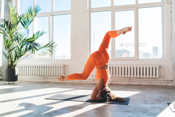 Flexible female athlete taking Supported Handstand pose in studio Stock ...