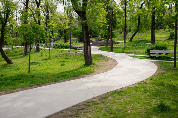 Winding walking concrete path in a summer park. Stock Photo by JulyKo