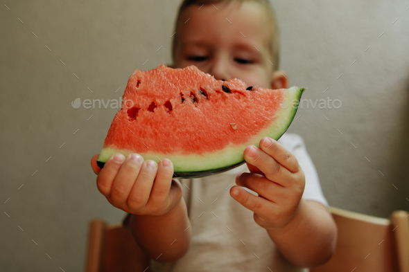 Cute child eating red juicy watermelon. Close -up. slice of watermelon ...