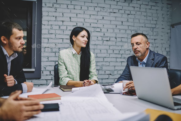 Professional employees in formal wear collaborating during office ...
