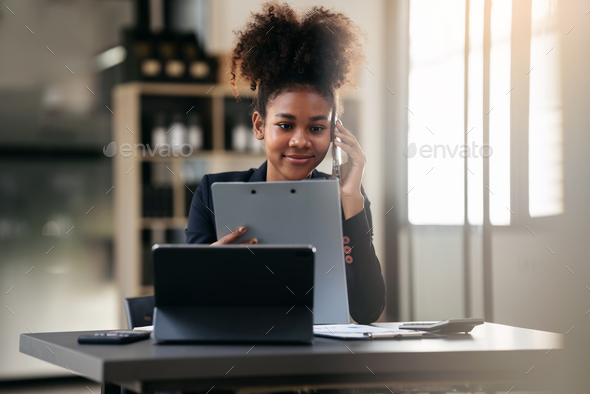African american businesswoman in suit holding paperwork to read Stock ...