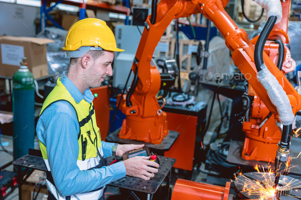 Worker man working with robot arm automate welding machine in modern ...