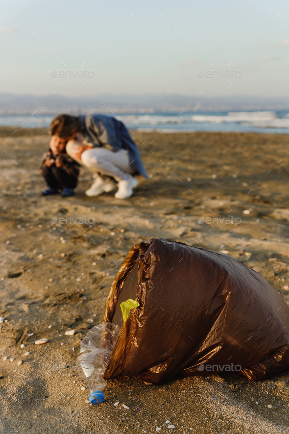 Mother is teaching her son to help keep nature clean. Focus on plastic ...