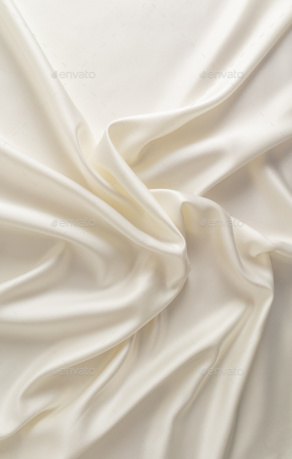 Elegant satin fabric with a creamy color. The luxurious texture of the soft folds of the fabric ...
