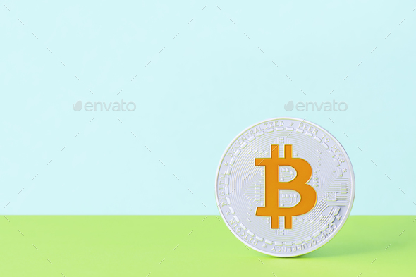 Silver Bitcoin with a gold symbol on a bright two-tone background ...