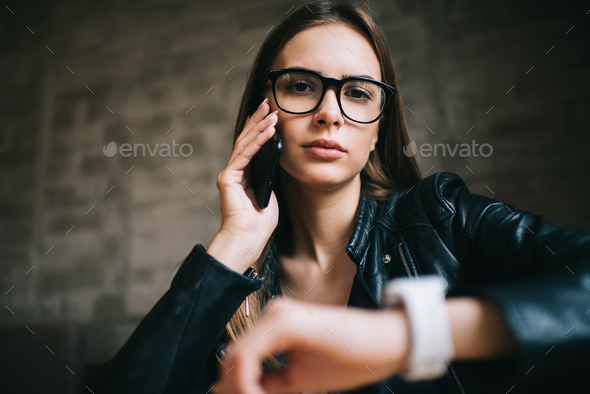 Millennial girl with smartwatch calling via app Stock Photo by GaudiLab
