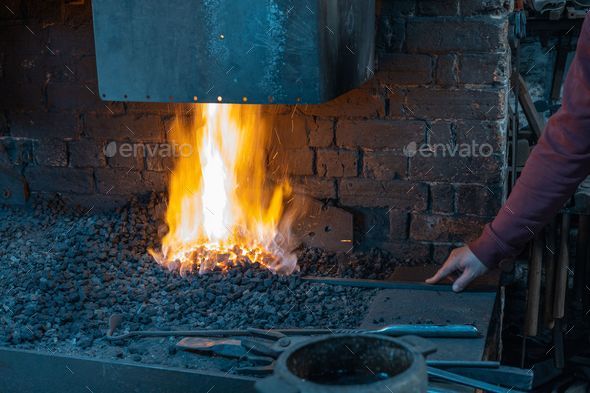 a person holding a handle over a piece of iron with a hot metal burning ...
