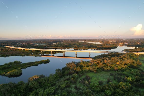 View of Fort Hamer Bridge and trees under the blue sky reflected in the ...