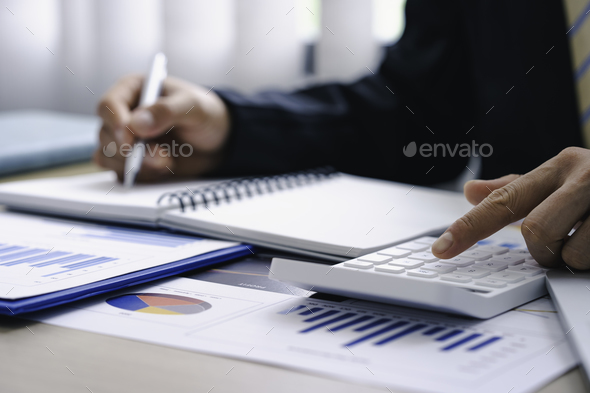 Businessman presses a calculator to calculate. and holding a pen and ...