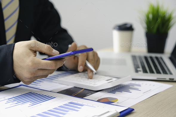 Businessman presses a calculator to calculate. and holding a pen and ...