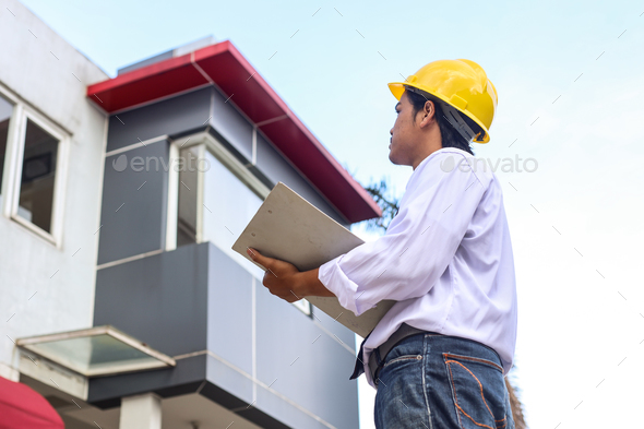 serious civil engineer working with documents on construction site ...