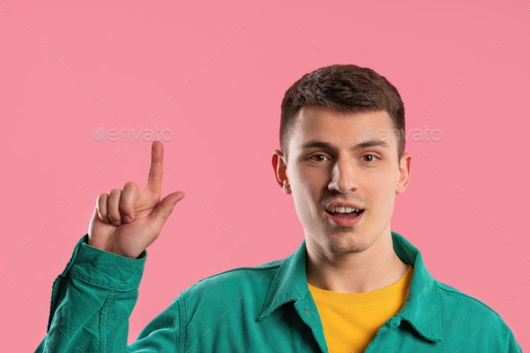 Brainy man having idea eureka moment, pointing finger up on pink ...