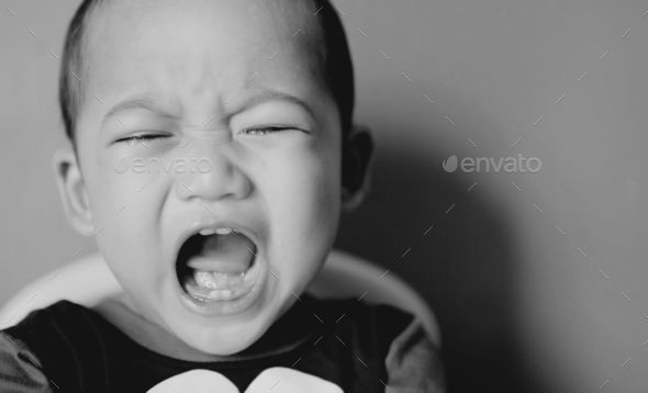 Grayscale shot of a crying boy with copy space Stock Photo by wirestock