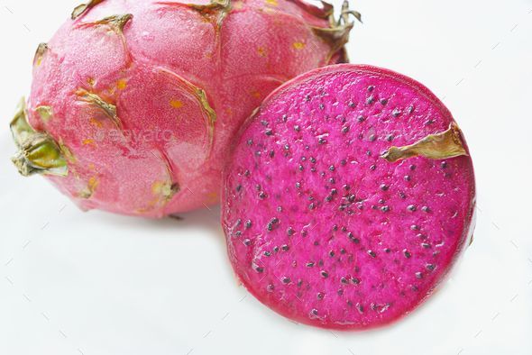 Cross section of a ripe red-fleshed pitaya and whole fruit, on white ...