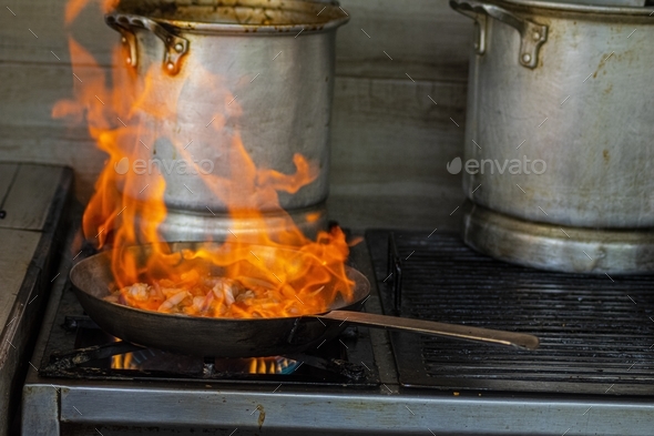 Process of frying and flaming shrimp in a pan Stock Photo by wirestock