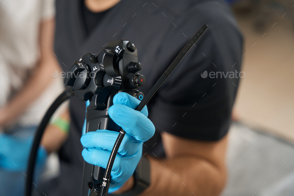 Professional endoscopist showing endoscopic equipment to patient Stock ...