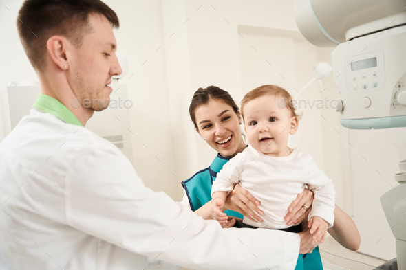 Focused X-ray technician preparing baby for radiography Stock Photo by ...