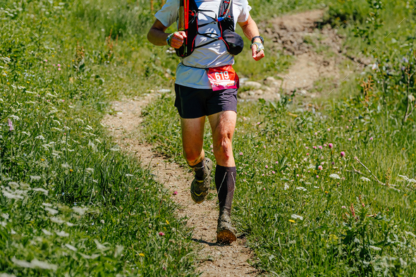 athlete runner running on trail marathon race, on his feet scratches ...