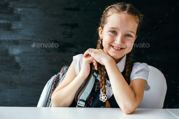 Cute happy smiling young girl wearing school uniform and backpack ...