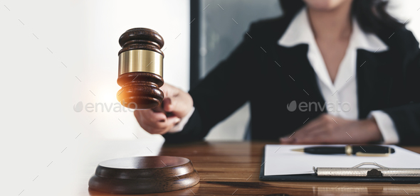 Woman judge hand holding gavel to bang on sounding block in the court ...