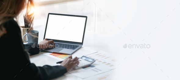 Young businesswoman using laptop computer at office, mockup blank white ...