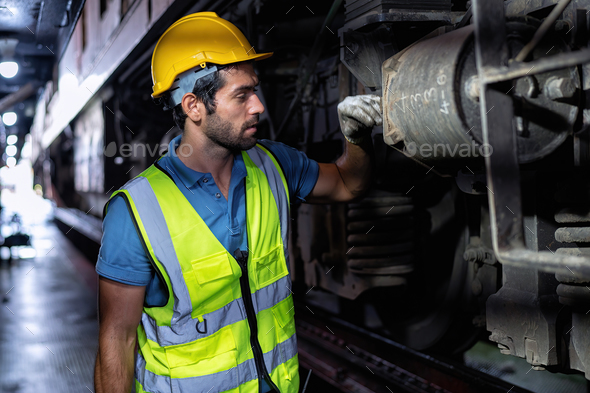 Mechanics service engineer working underneath train car maintenance ...