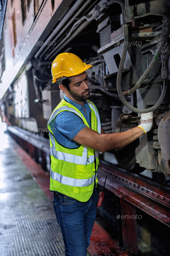 Mechanics service engineer working underneath train car maintenance ...