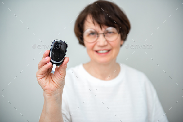Senior woman using digital glucometer at home. Diabetes control Stock ...