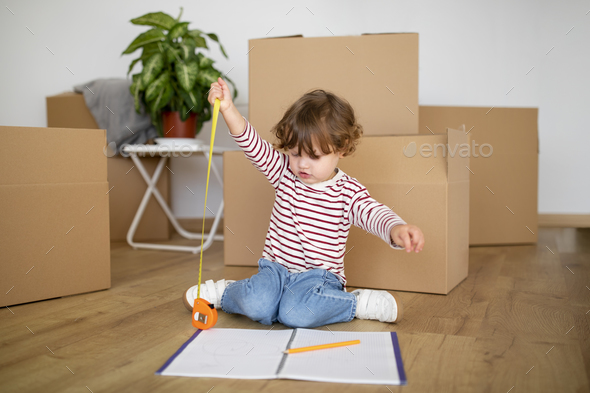 Adorable Little Boy Playing With Tape Ruler On Moving Day At Home Stock ...