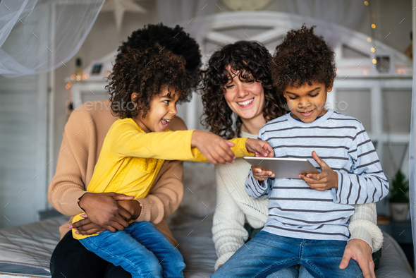 Happy multiethnic family having fun with digital device at home. Family ...